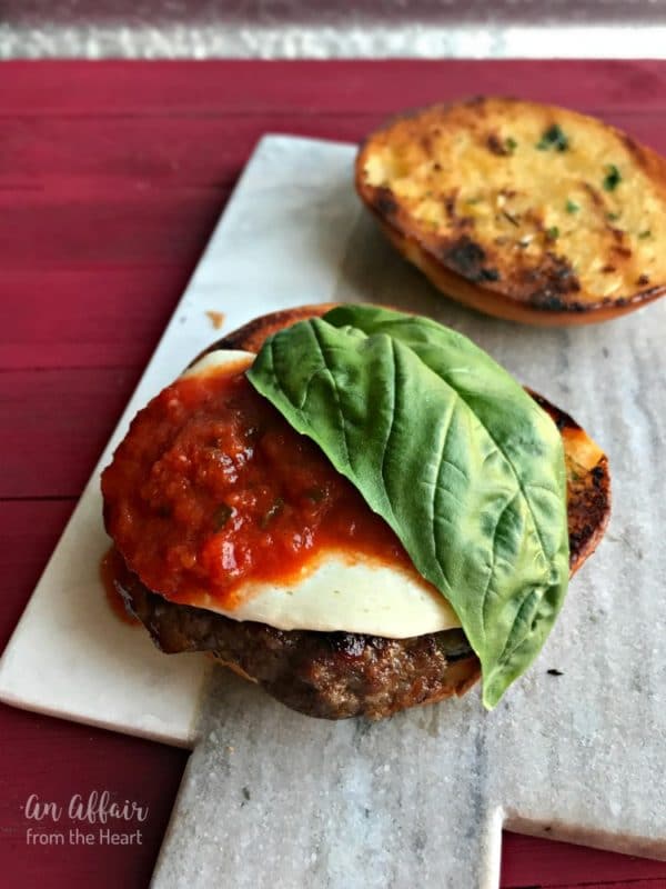 Italian Burger with fresh basil and mozzarella on a garlic bread bun.