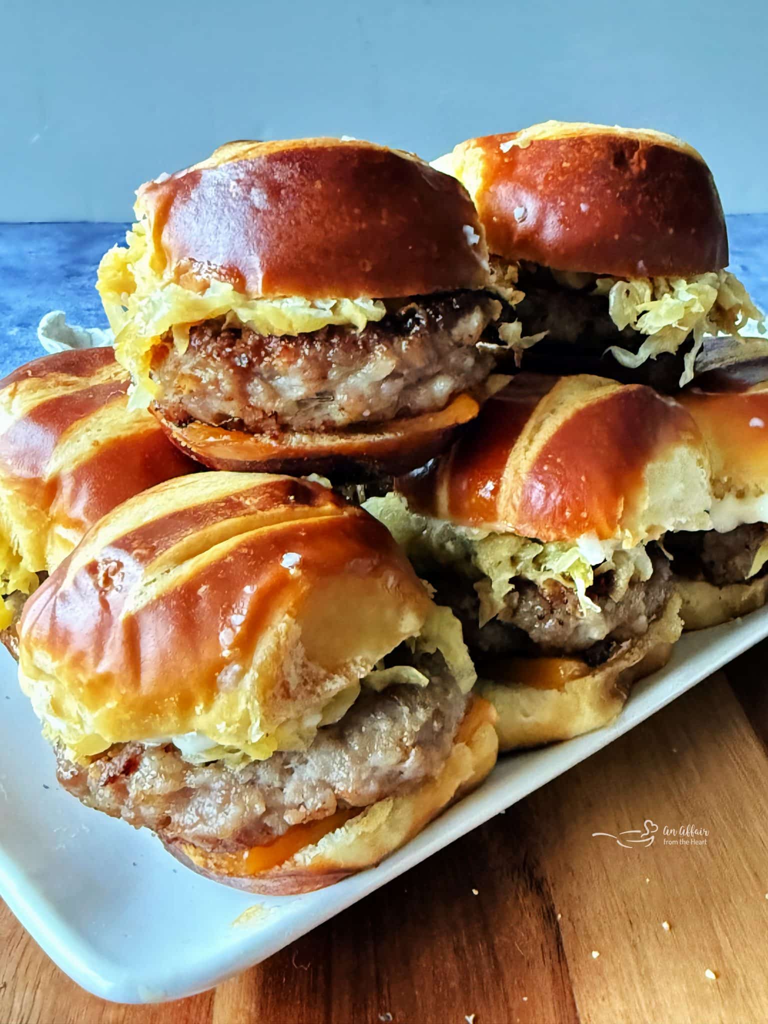 Bratwurst Sliders with Mustard Kraut on Pretzel Buns