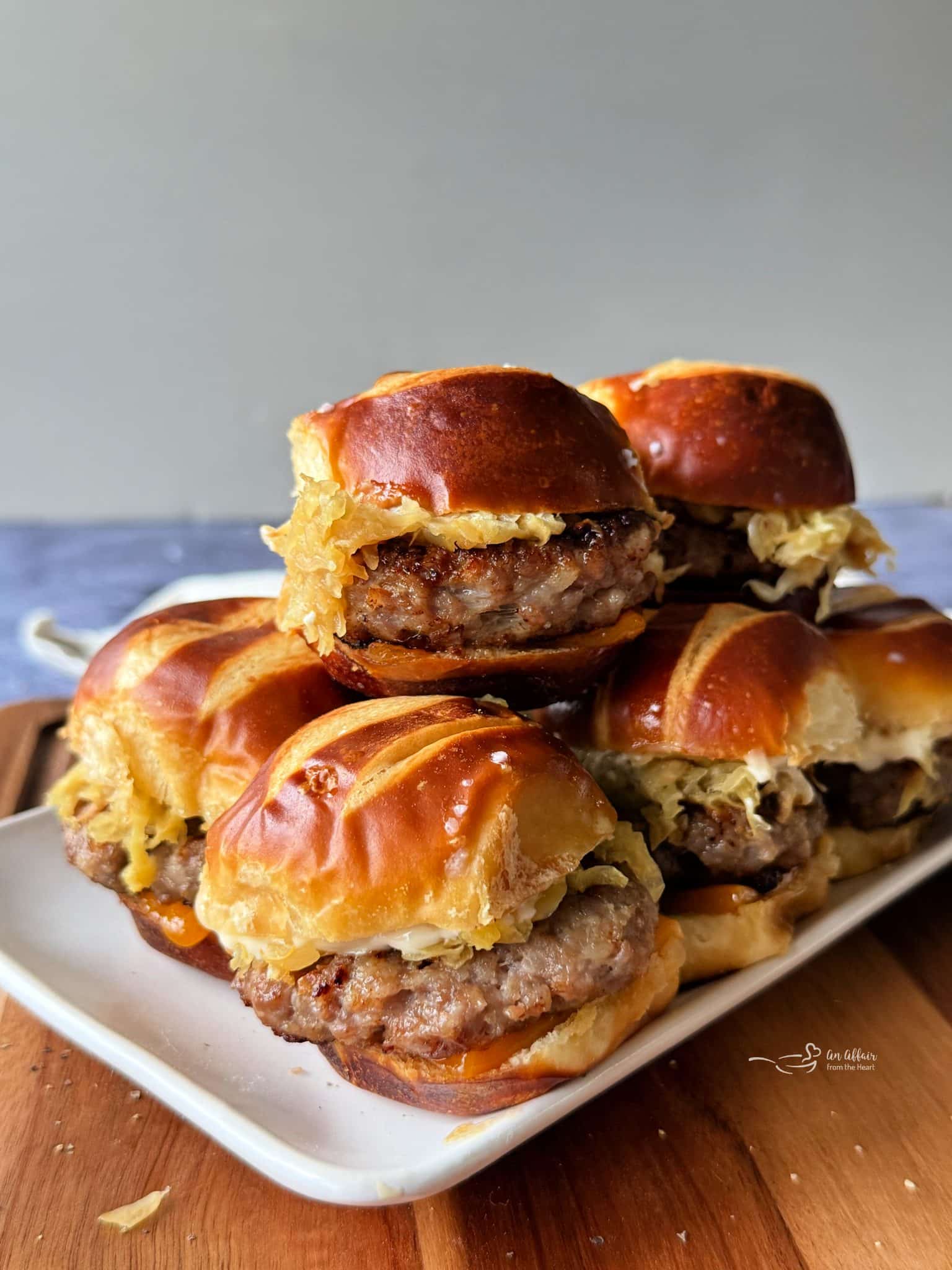 Bratwurst Sliders with Mustard Kraut on Pretzel Buns